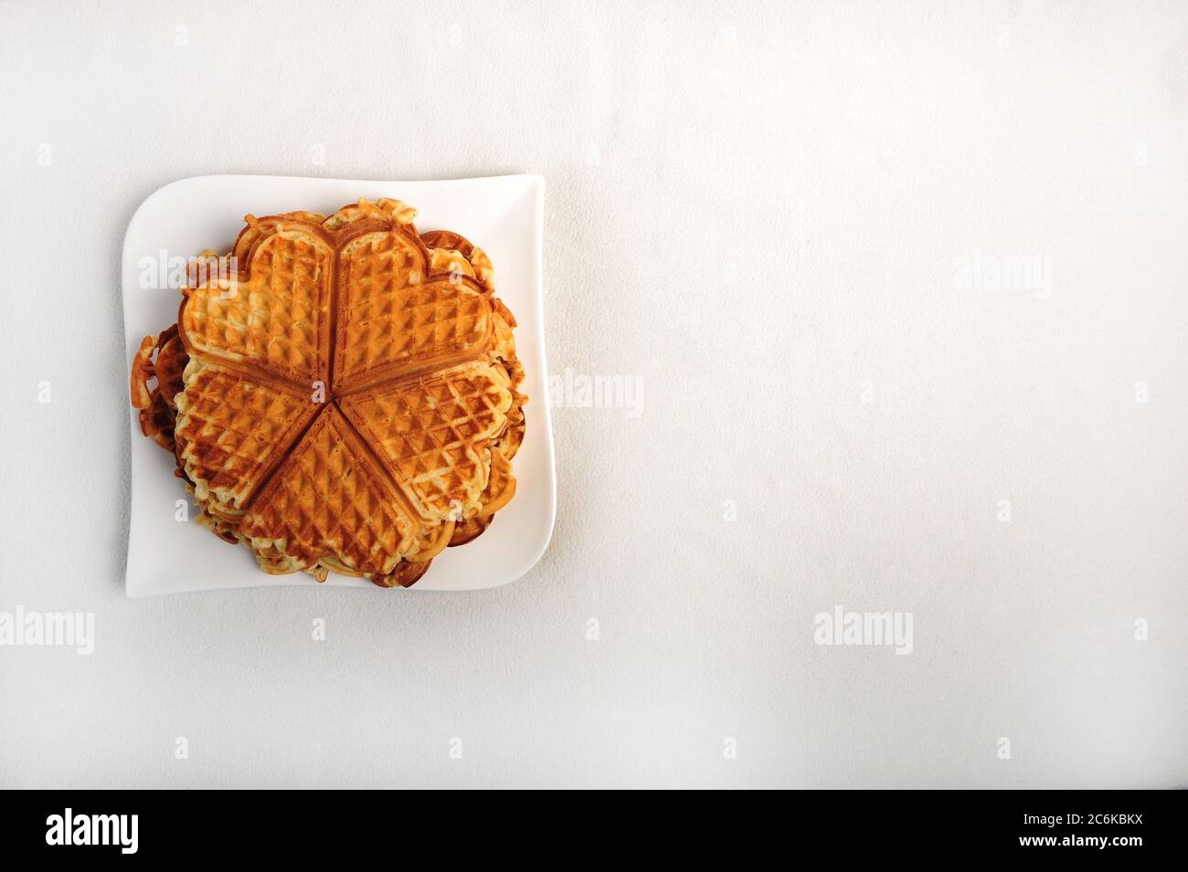 Top view angle of stack of Norwegian waffles on white plate. Copy space ...