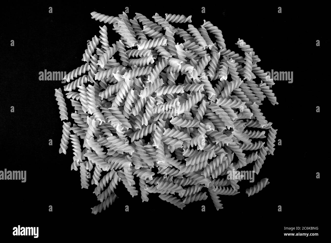 Black and white shot of pasta screws on black cloth. High angle view ...