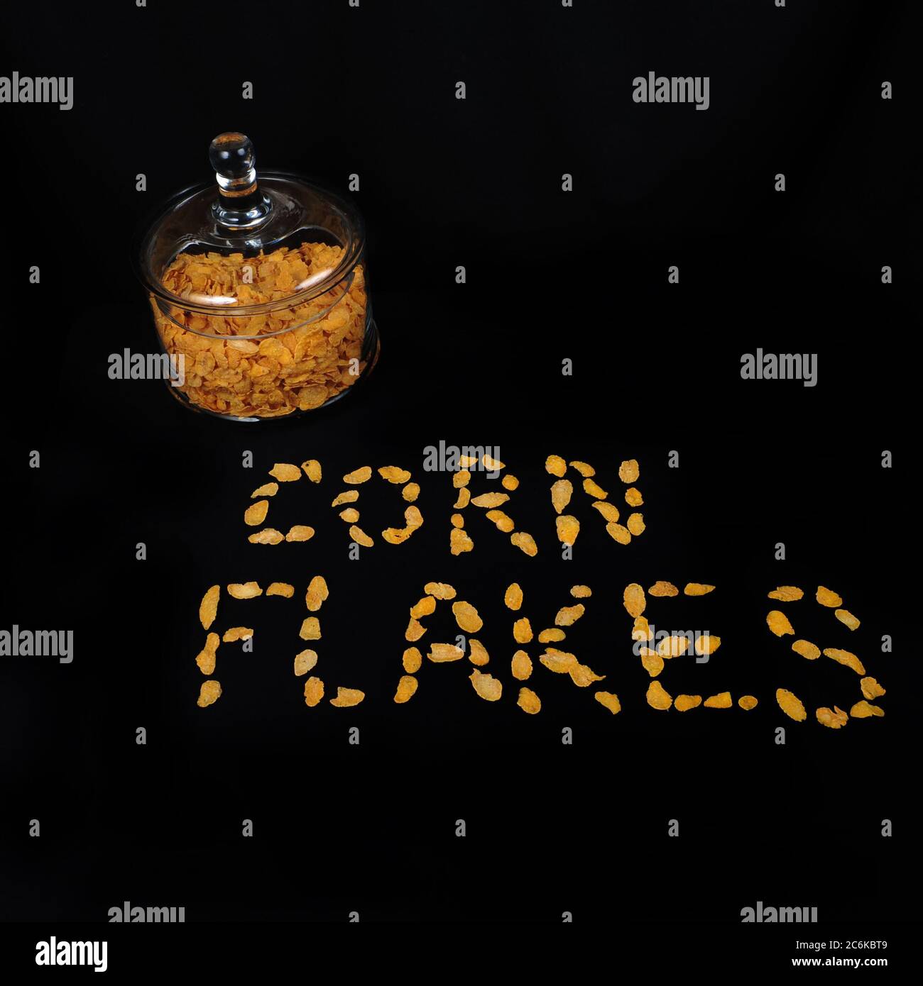 Square shot of cornflakes in glass bowl with lid. Corn flakes spread ...