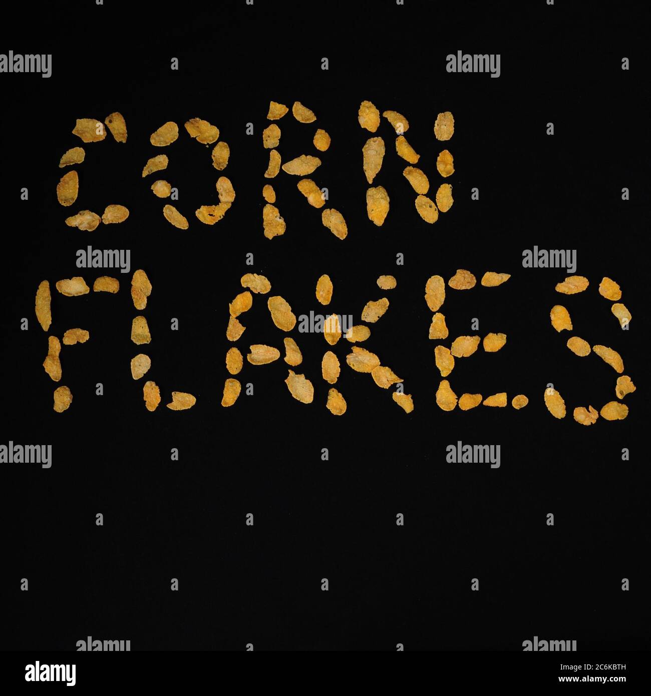 Square shot of cornflakes spelling the words "CORN FLAKES"l. Glass lid ...