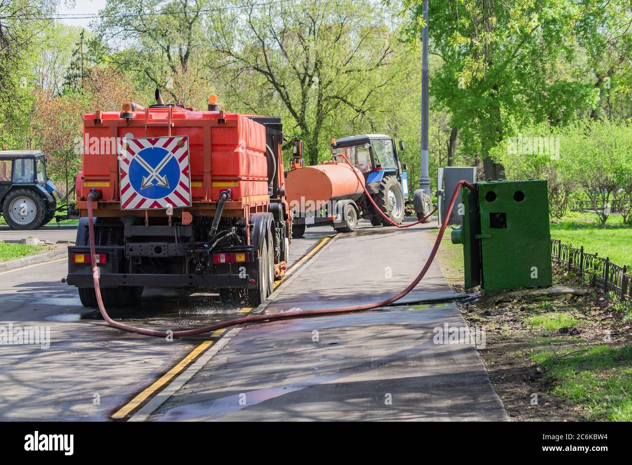 street cleaning sweeper machines pumping water for washing asphalt road ...