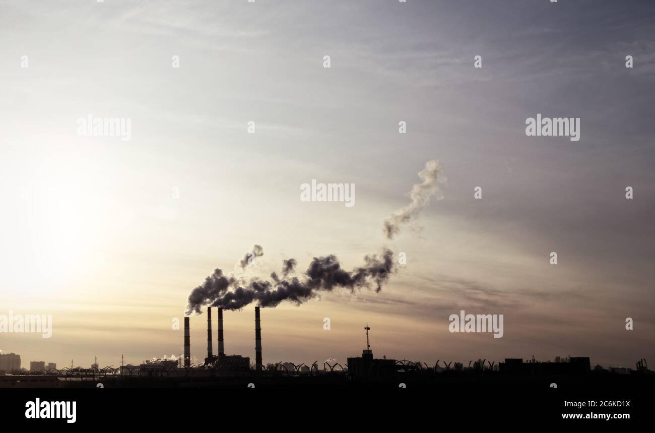 Spring, evening setting sun and smoking plant pipes. Dissonance of pure ...