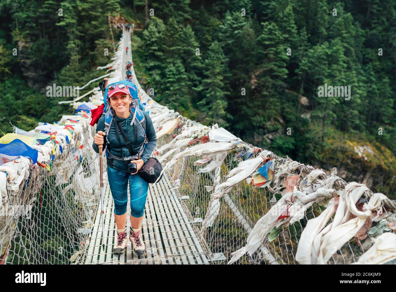 Girl crossing bridge with prayer flags hi-res stock photography and ...