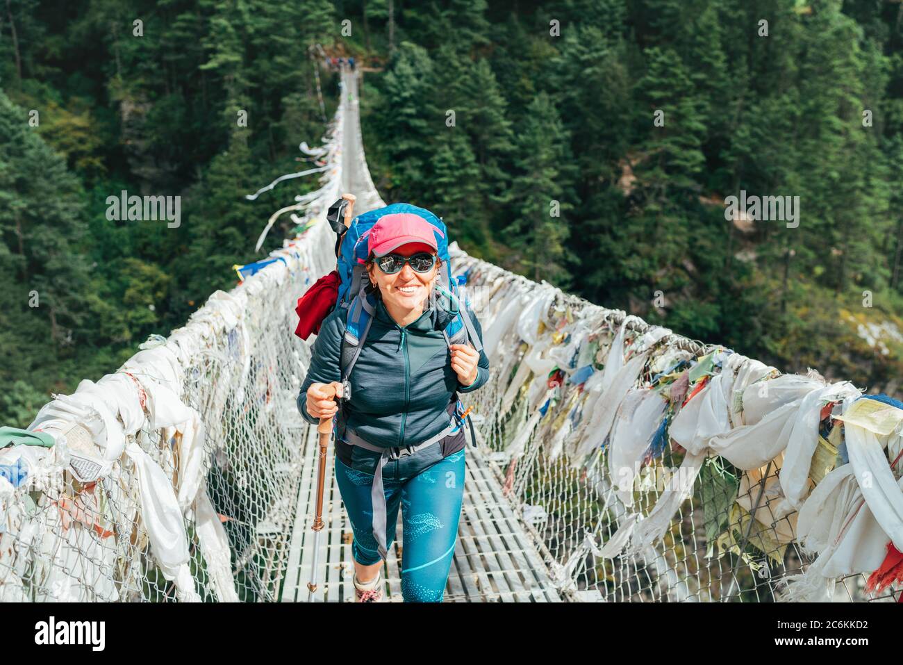 Girl crossing bridge with prayer flags hi-res stock photography and ...