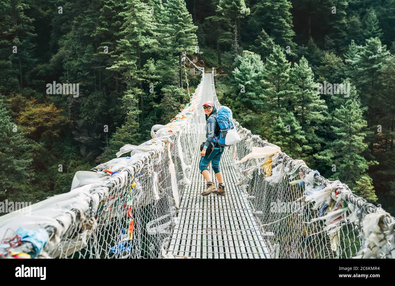 Girl crossing bridge with prayer flags hi-res stock photography and ...