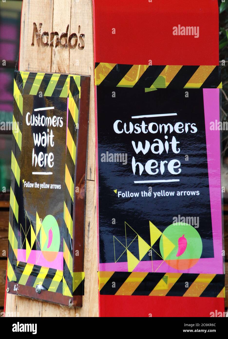 Customers Wait Here sign seen outside Nandos restaurant Stock Photo - Alamy