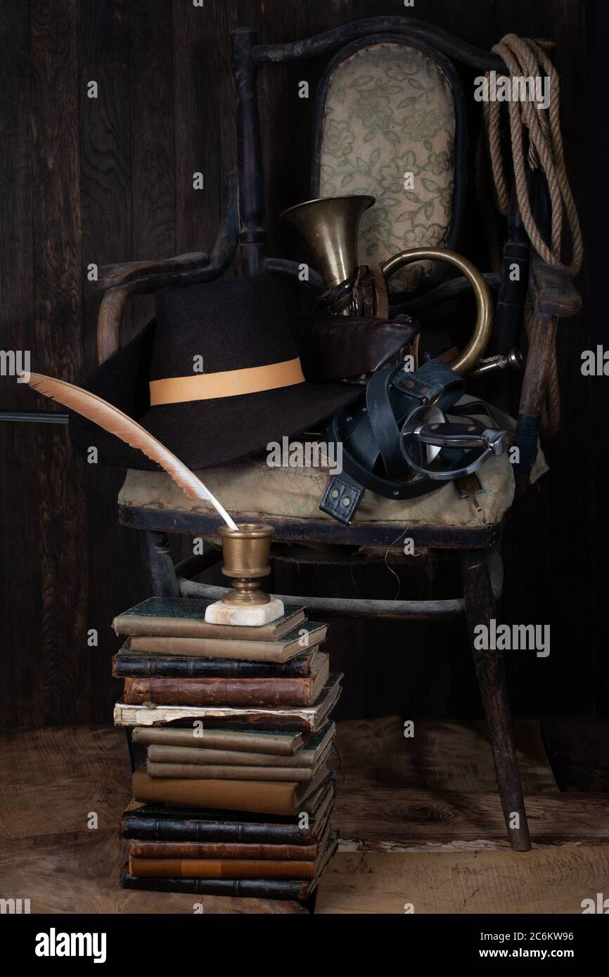 Adventure fiction - Vintage broken wooden chair with hat, sword, bugle ...