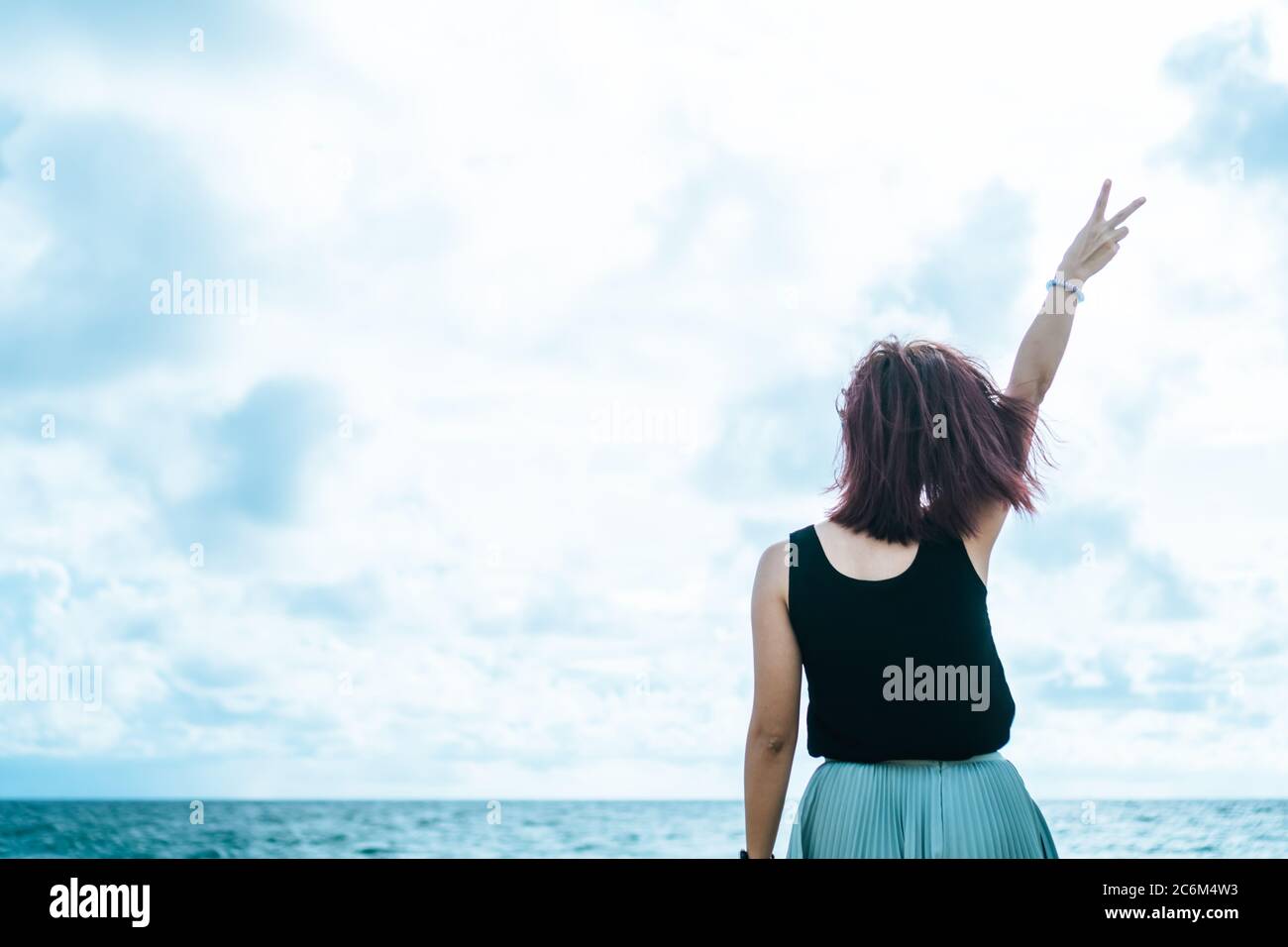 Woman rise hands up to sky freedom concept with sunset sky and summer ...