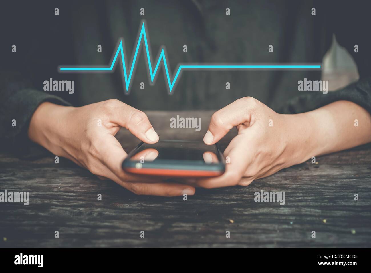 Woman hand holding smartphone with vital sign of heart beat background ...
