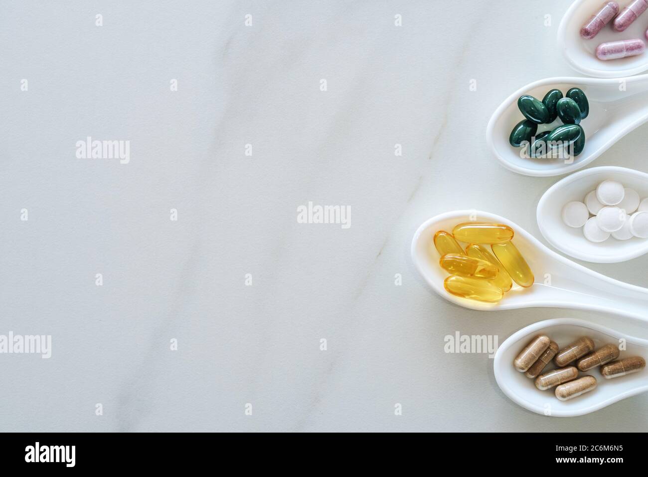 Top view of natural vitamin supplement on white spoon as frame of ...