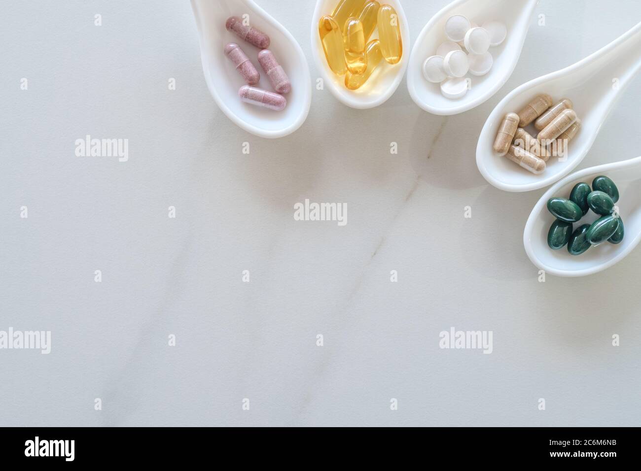 Top view of natural vitamin supplement on white spoon as frame of ...