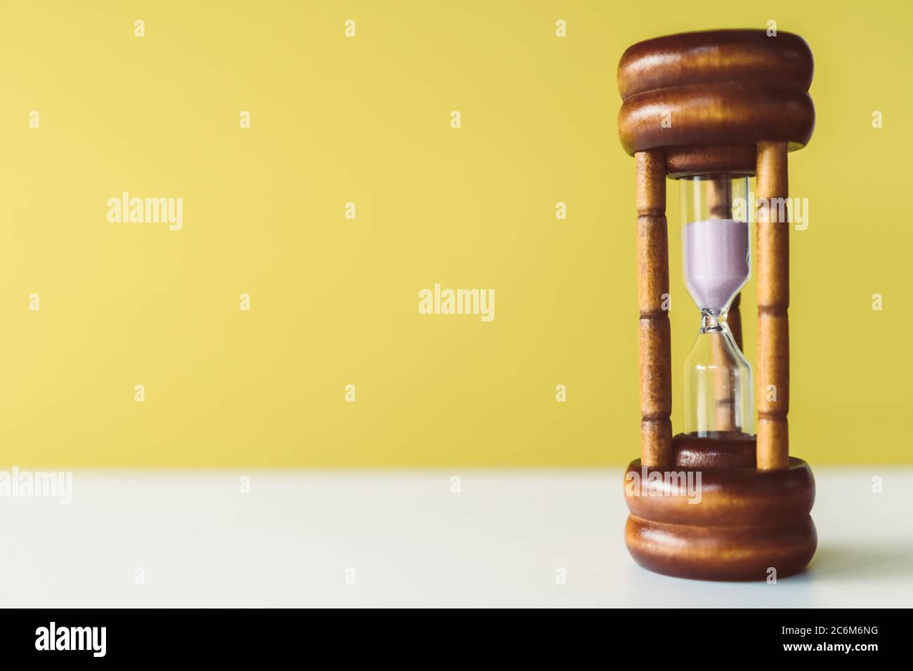 Selective focus of wooden hourglass on yellow background. Time and life ...