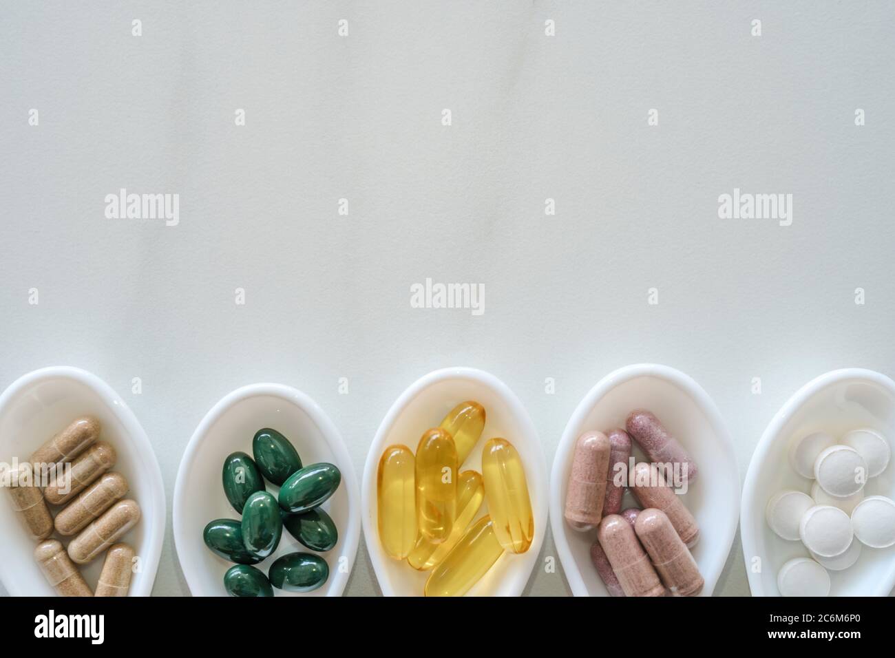 Top view of natural vitamin supplement on white spoon as frame of ...