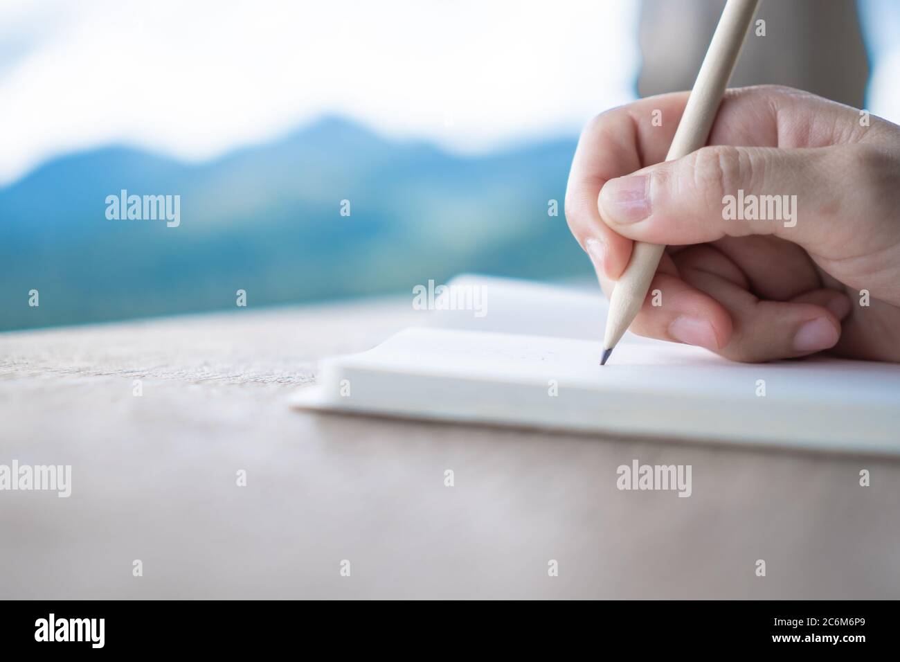 Woman hand writing down in small white memo notebook for take a note ...