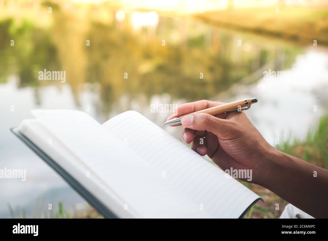 Woman hand writing down in small white memo notebook for take a note ...