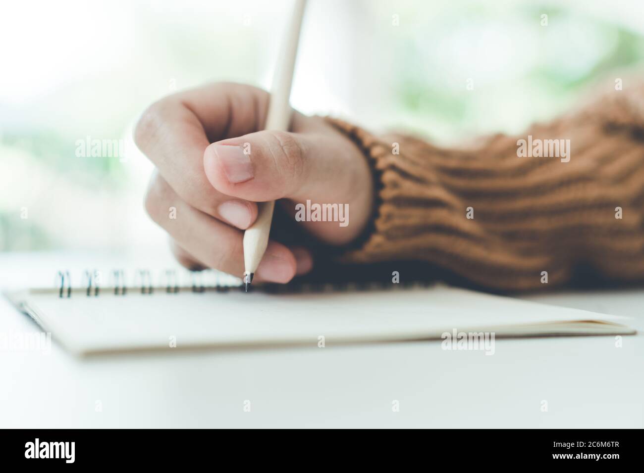 Woman hand write down in white memo notebook for take a note not to ...