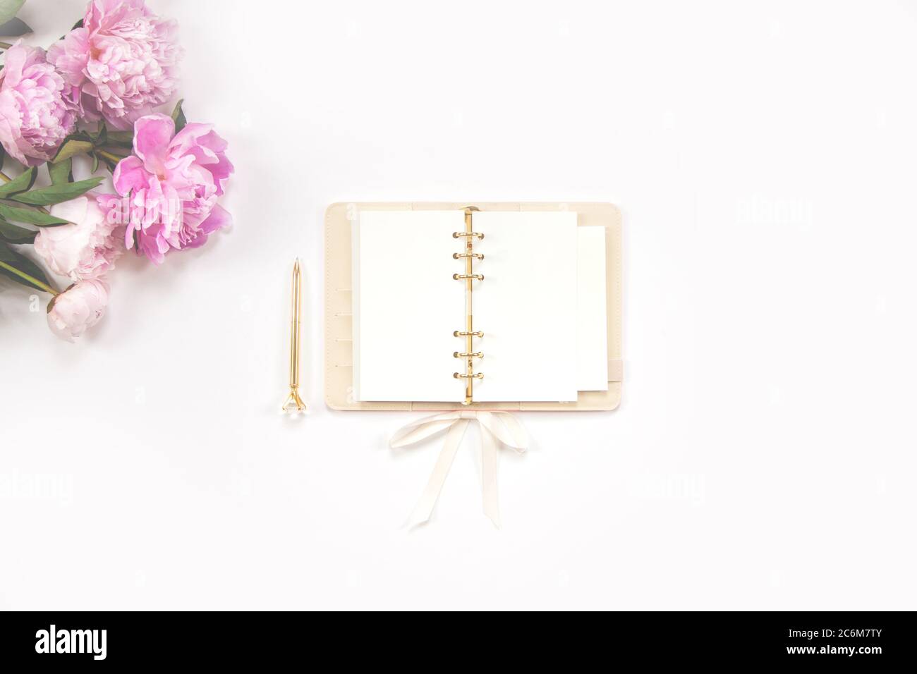 Female diary, golden pen and pink peonies on a white background. Copy ...
