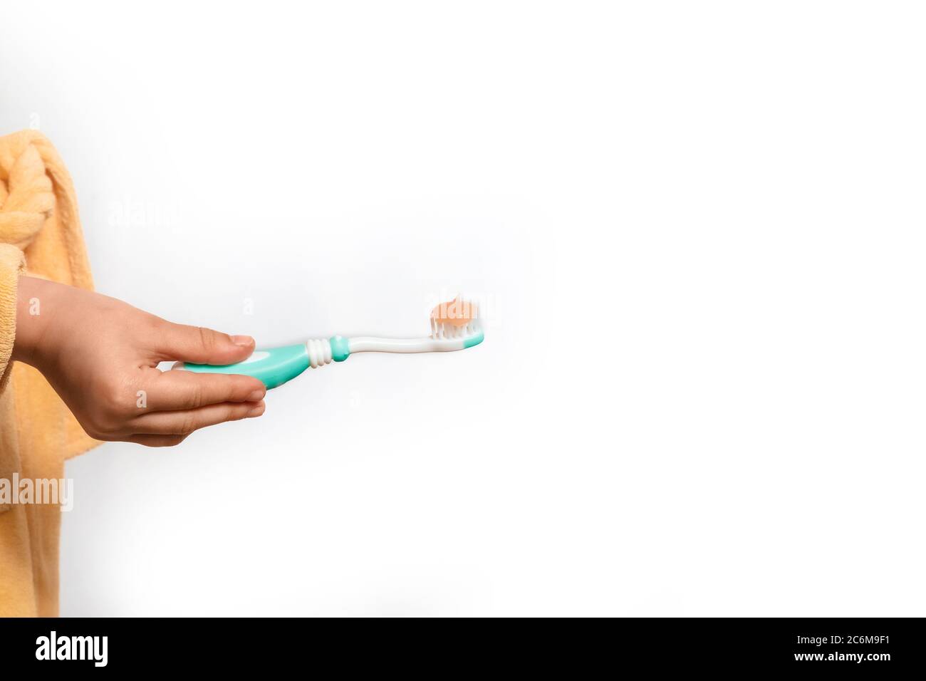Child's hands holding big tooth and toothbrush on white background ...