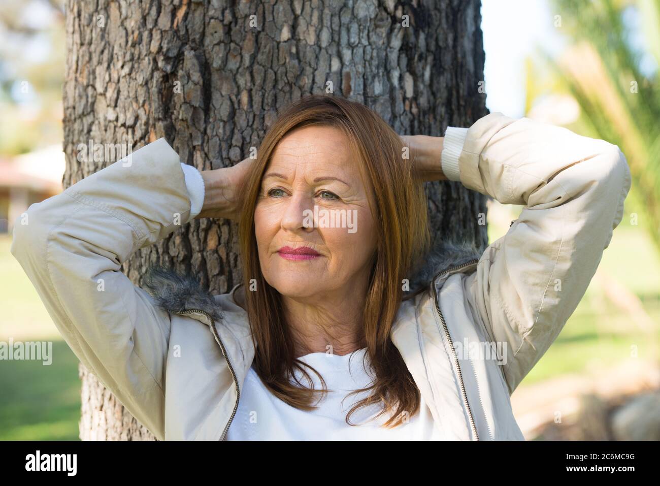 Portrait attractive mature woman relaxed in park with closed eyes ...