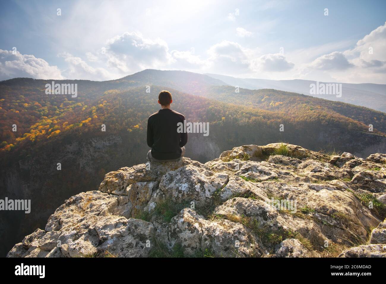 Man sitting on the cliff. Conceptual scene. Mountain nature edge ...