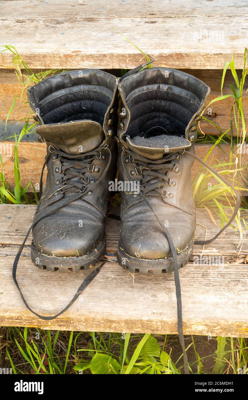 Old leather Hiking boots on the porch of a village house. Summer is a ...