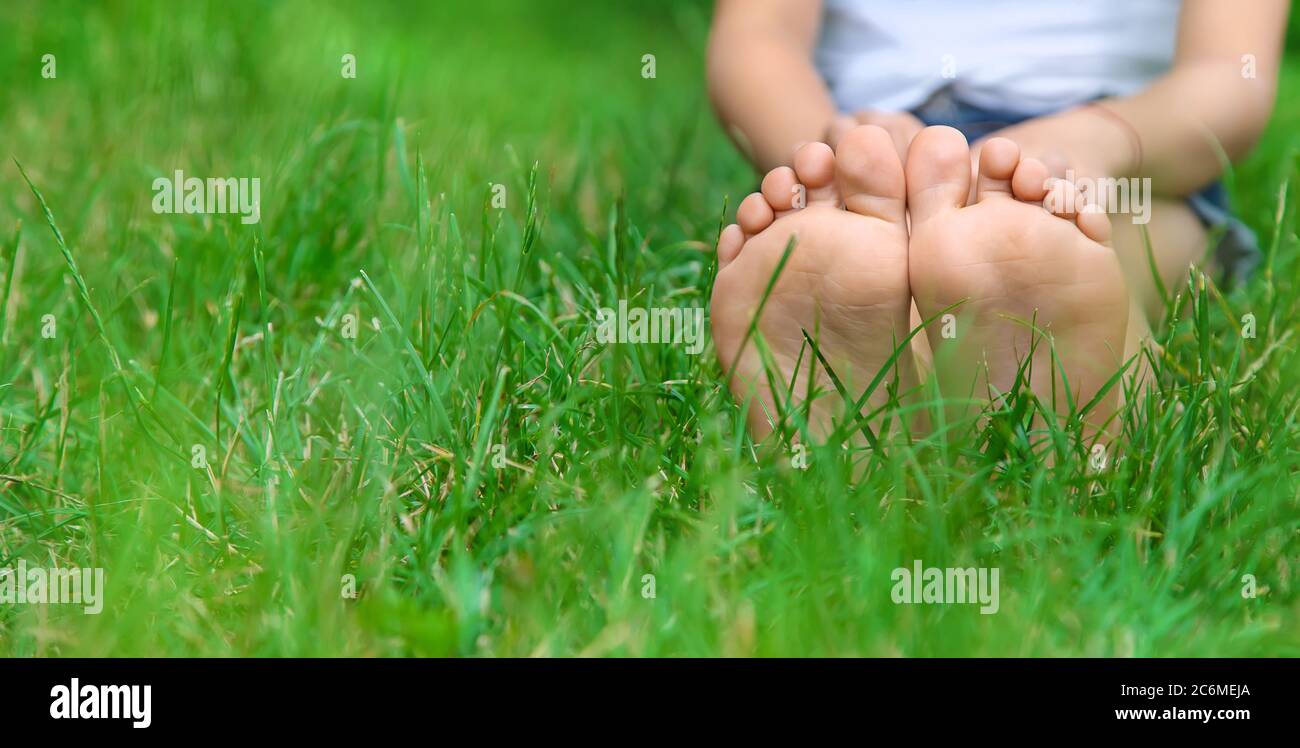 Children's feet on the green grass in the park. Selective focus. nature ...