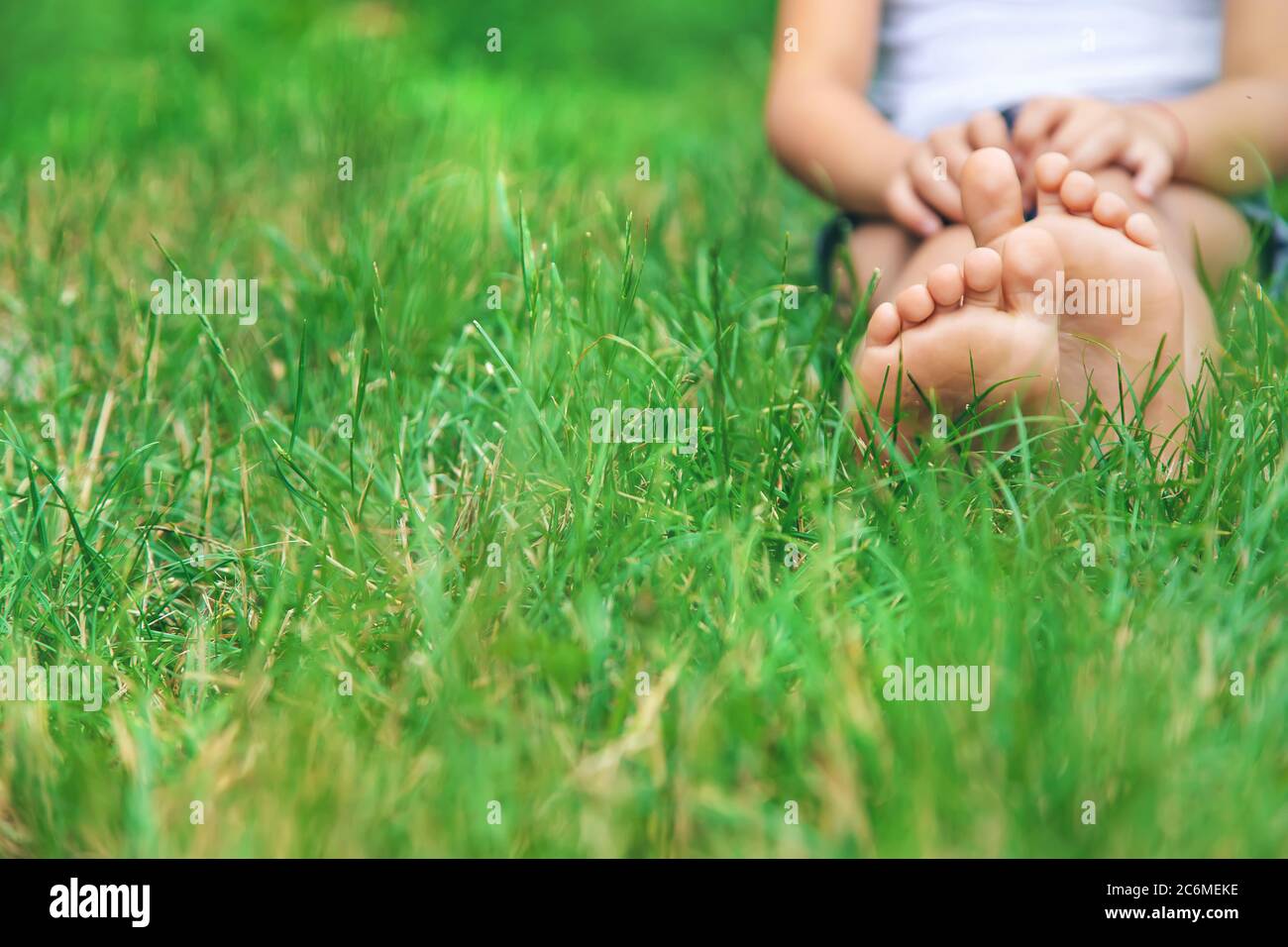 Children's feet on the green grass in the park. Selective focus. nature ...