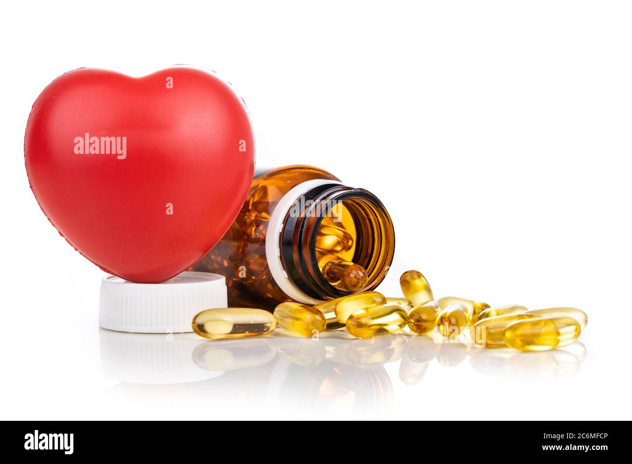 Fish oil gel capsule with bottle and heart shaped prop against white ...