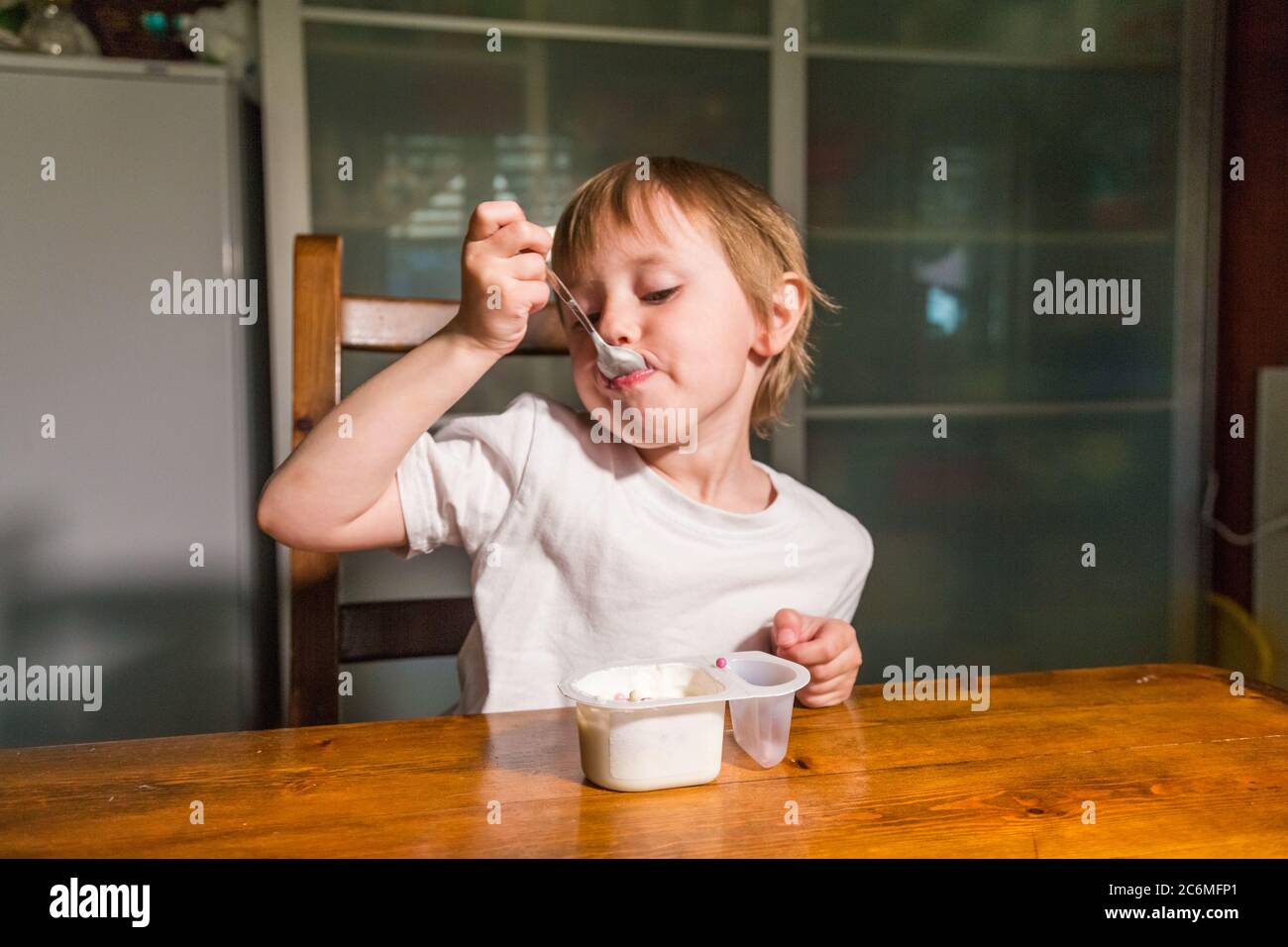 Adorable baby girl eating cottage cheese from spoon, healthy milk snack ...