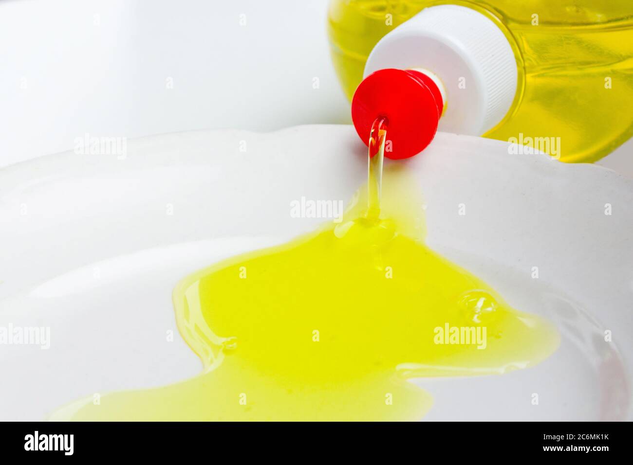 Yellow detergent from the bottle spreads on a white plate Stock Photo ...