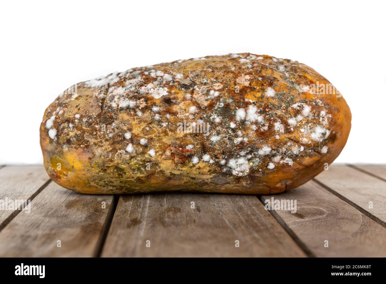 Rotten and decomposing papaya with mold and fungus on wooden table ...