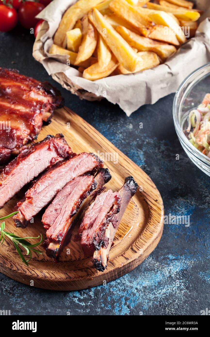 Spicy barbecued pork ribs served with BBQ sauce on chopping board Stock ...