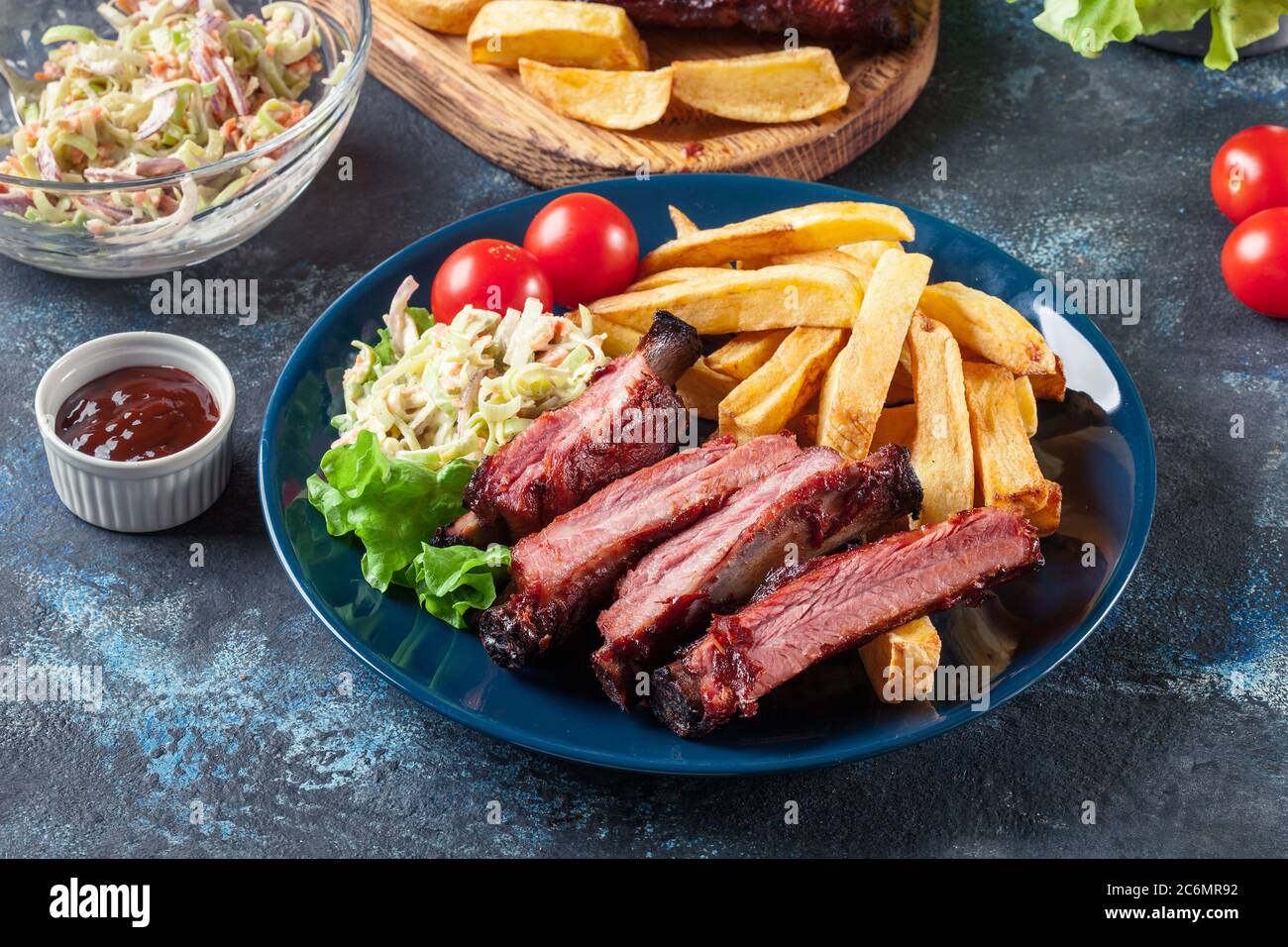 Spicy barbecued pork ribs served with french fries and BBQ sauce Stock ...