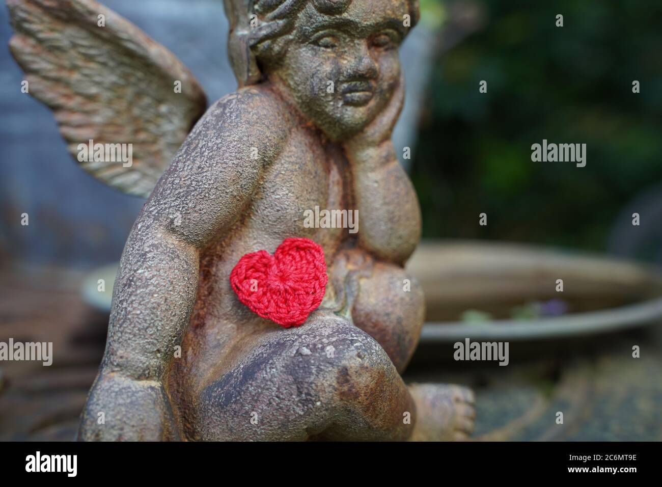 Dreamy angel statue with a crocheted red heart Stock Photo - Alamy