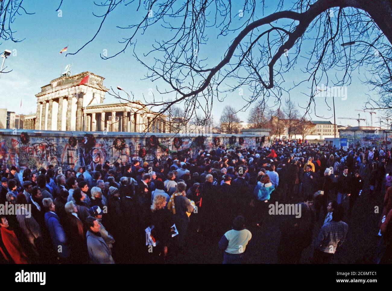 A crowd gathers at the Berlin Wall near the Brandenburg Gate following ...