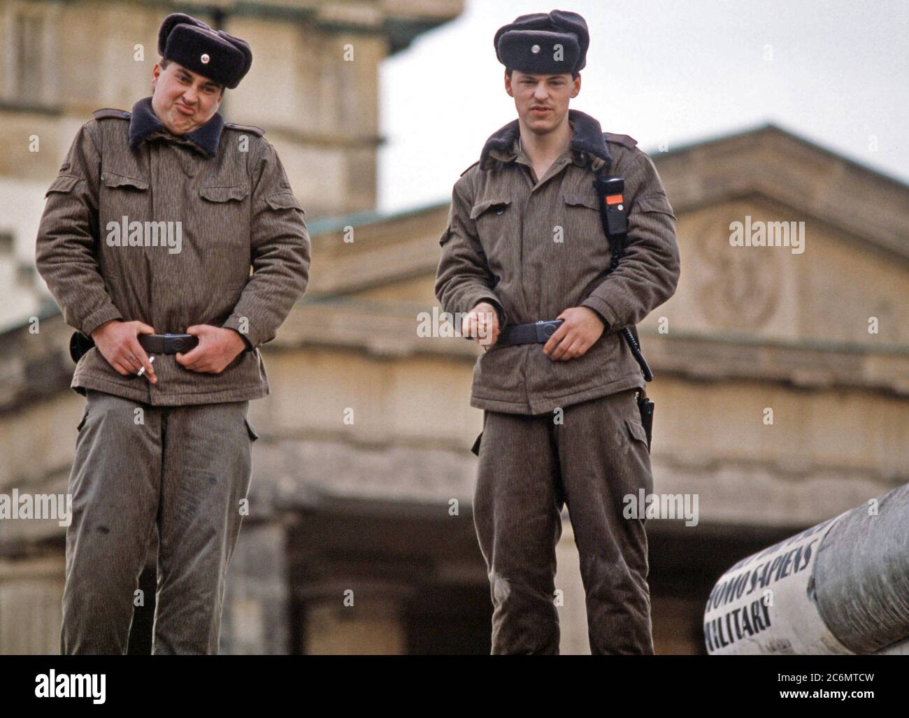 East German guards stand atop the Berlin Wall beside the Brandenburg ...