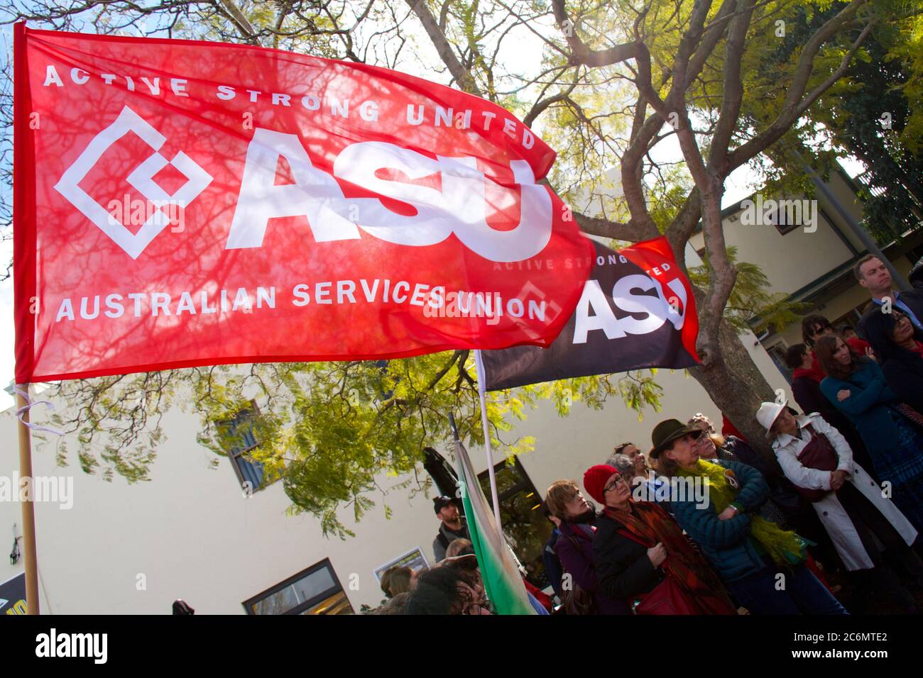 Some people held ASU (Australian Services Union) flags as they listened ...