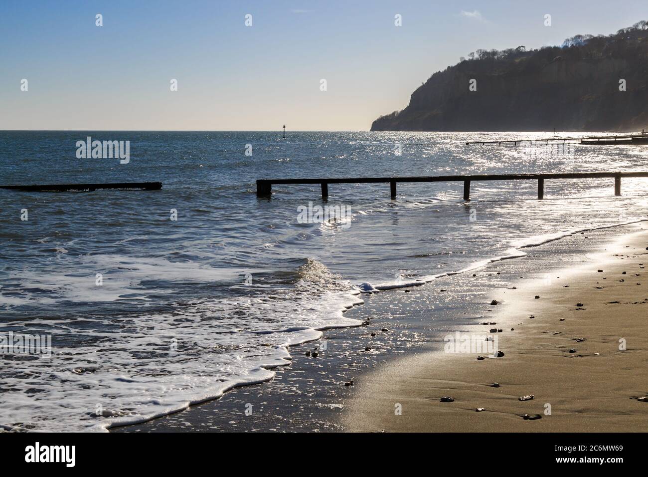 Sunlight shining on the waters edge, at Shanklin beach on the Isle of ...