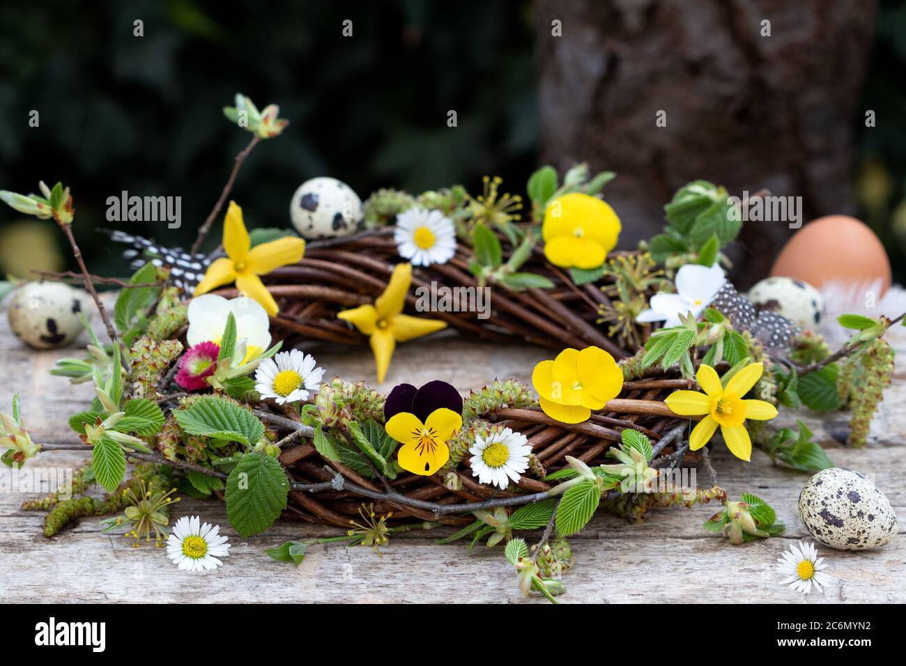 willow wreath with spring flowers and branches as easter decoration ...