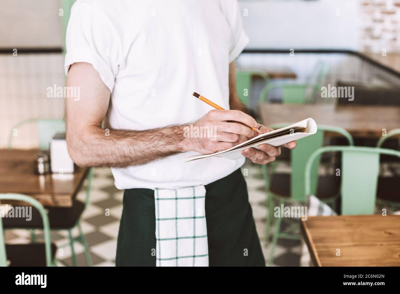 Close up photo of waiter standing with pencil and writing order in ...