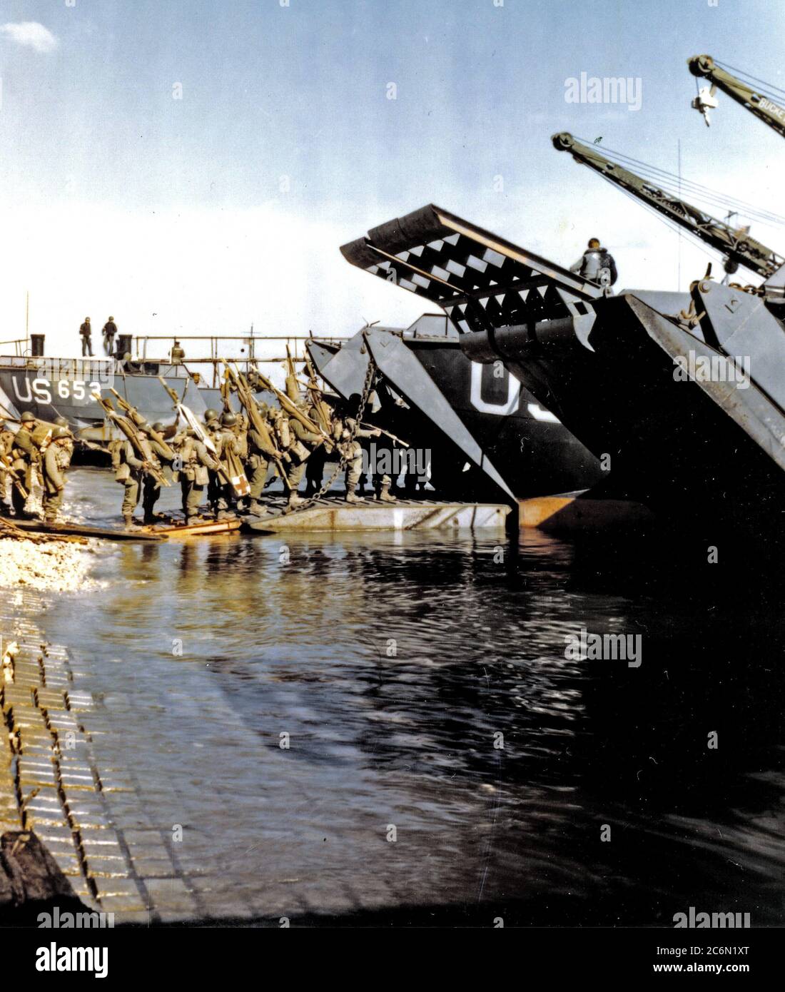 Medics and litter bearers going up the ramp of an LCT which will take ...