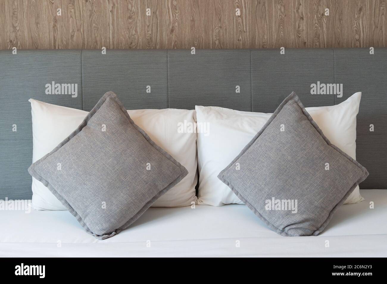 Luxury stacking of pillows on bed, white bed sheets with wooden bedhead ...