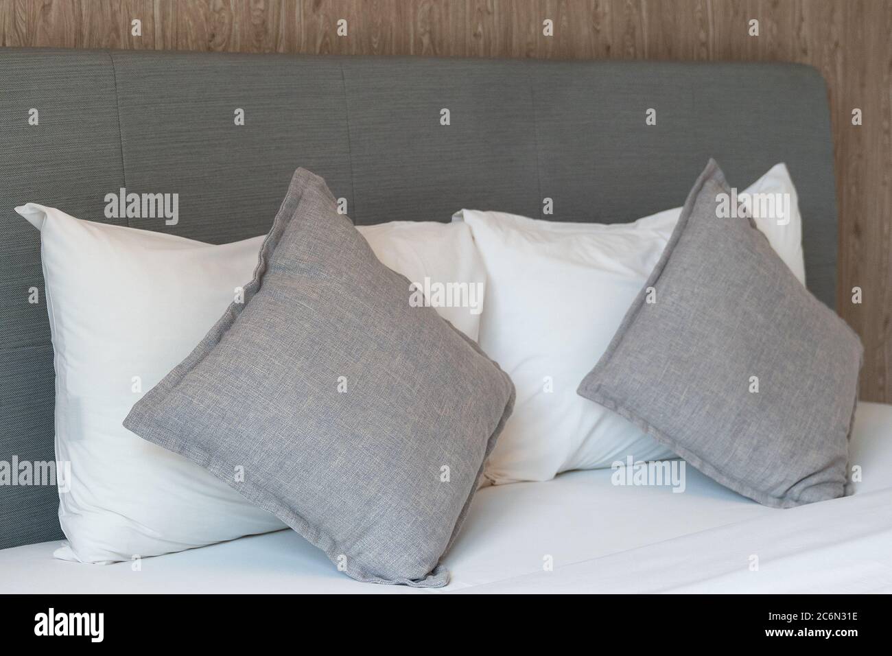 Luxury stacking of pillows on bed, white bed sheets with wooden bedhead ...
