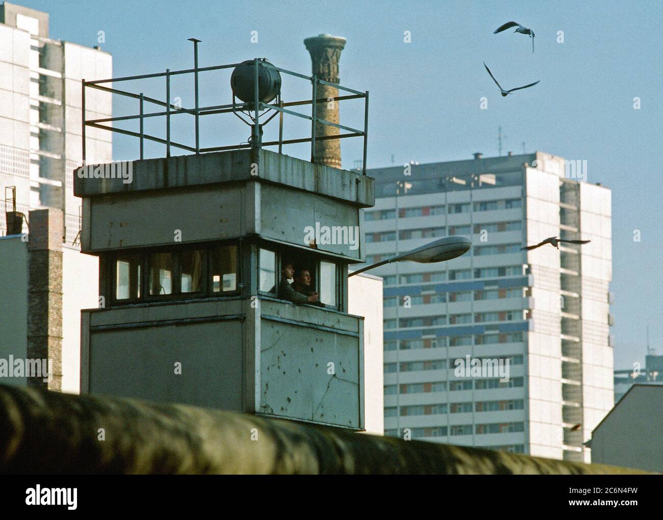 East German guards feed the birds from their post at the Berlin Wall ...