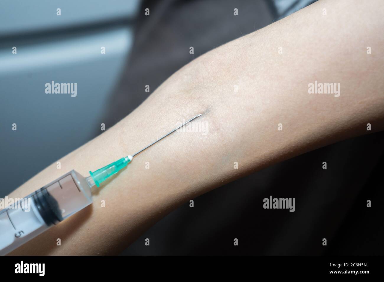 A syringe enters the patient's vein. doctor makes an injection to the ...
