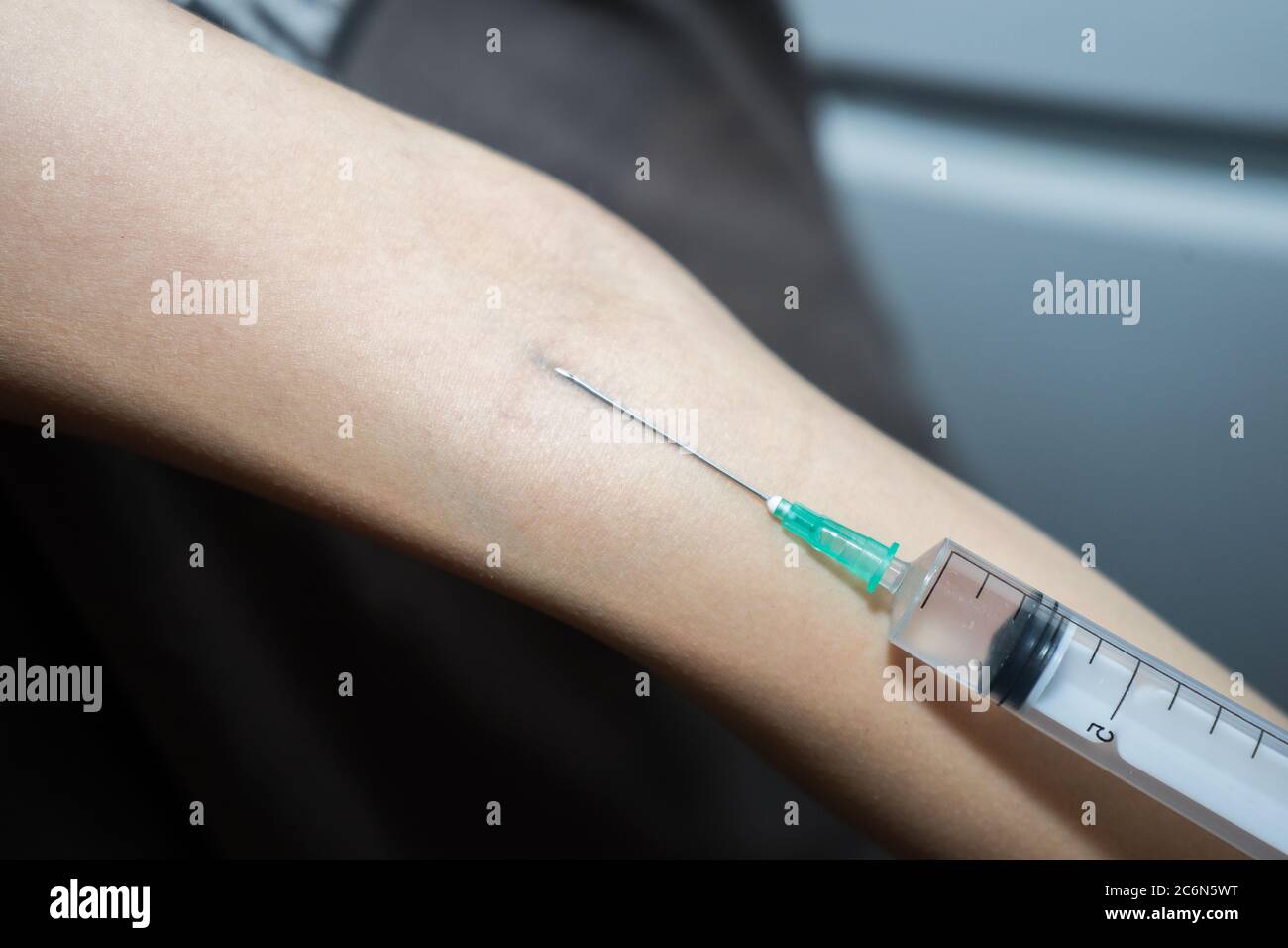 A syringe enters the patient's vein. doctor makes an injection to the ...