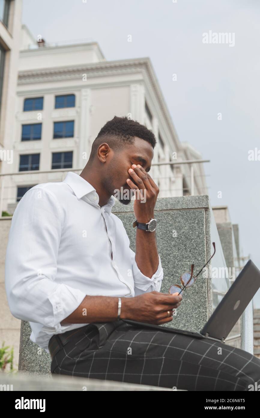 Feeling exhausted. Frustrated young black african man keeping eyes ...