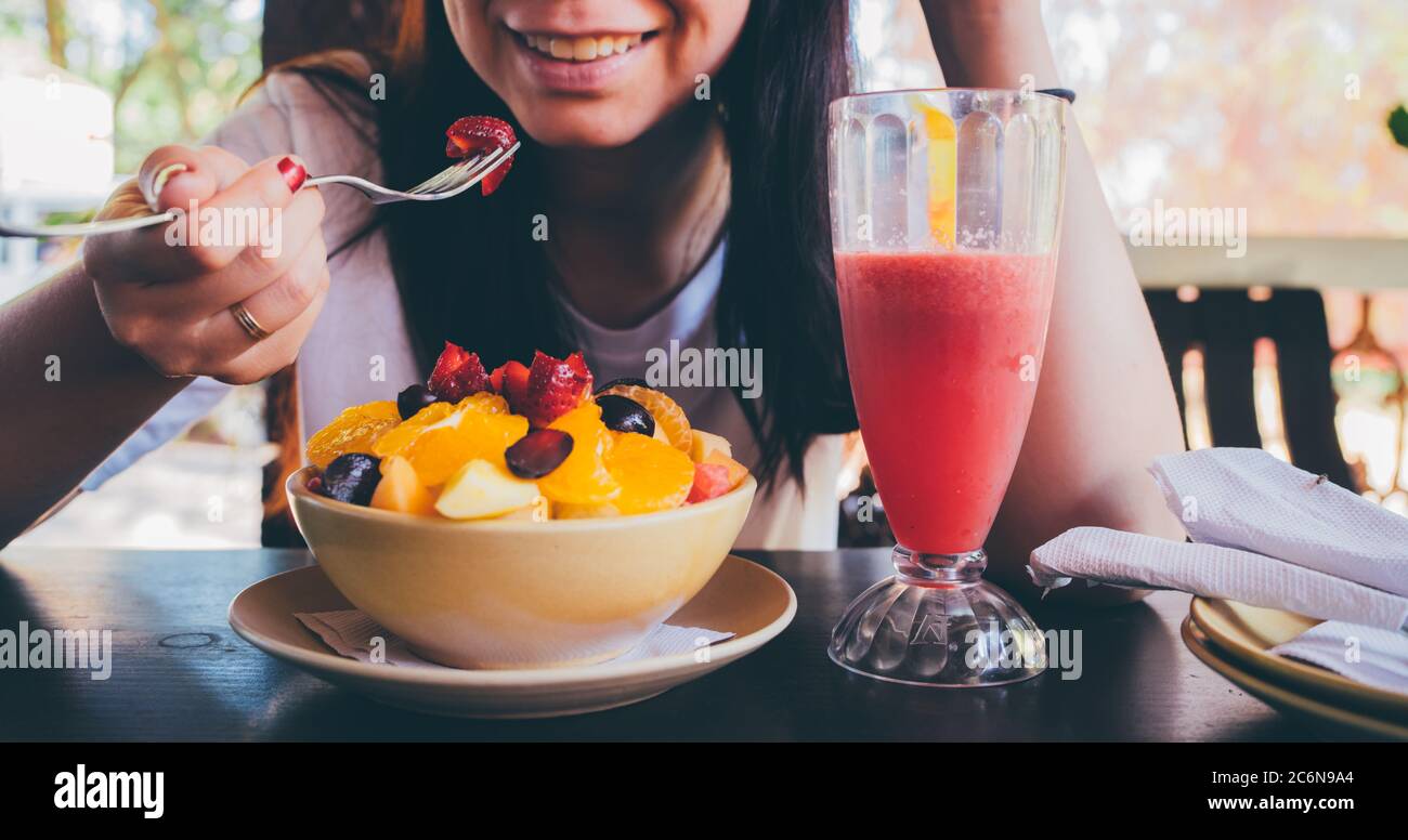 Woman trying exotic dish in street cafe. Adult lady taking piece of ...