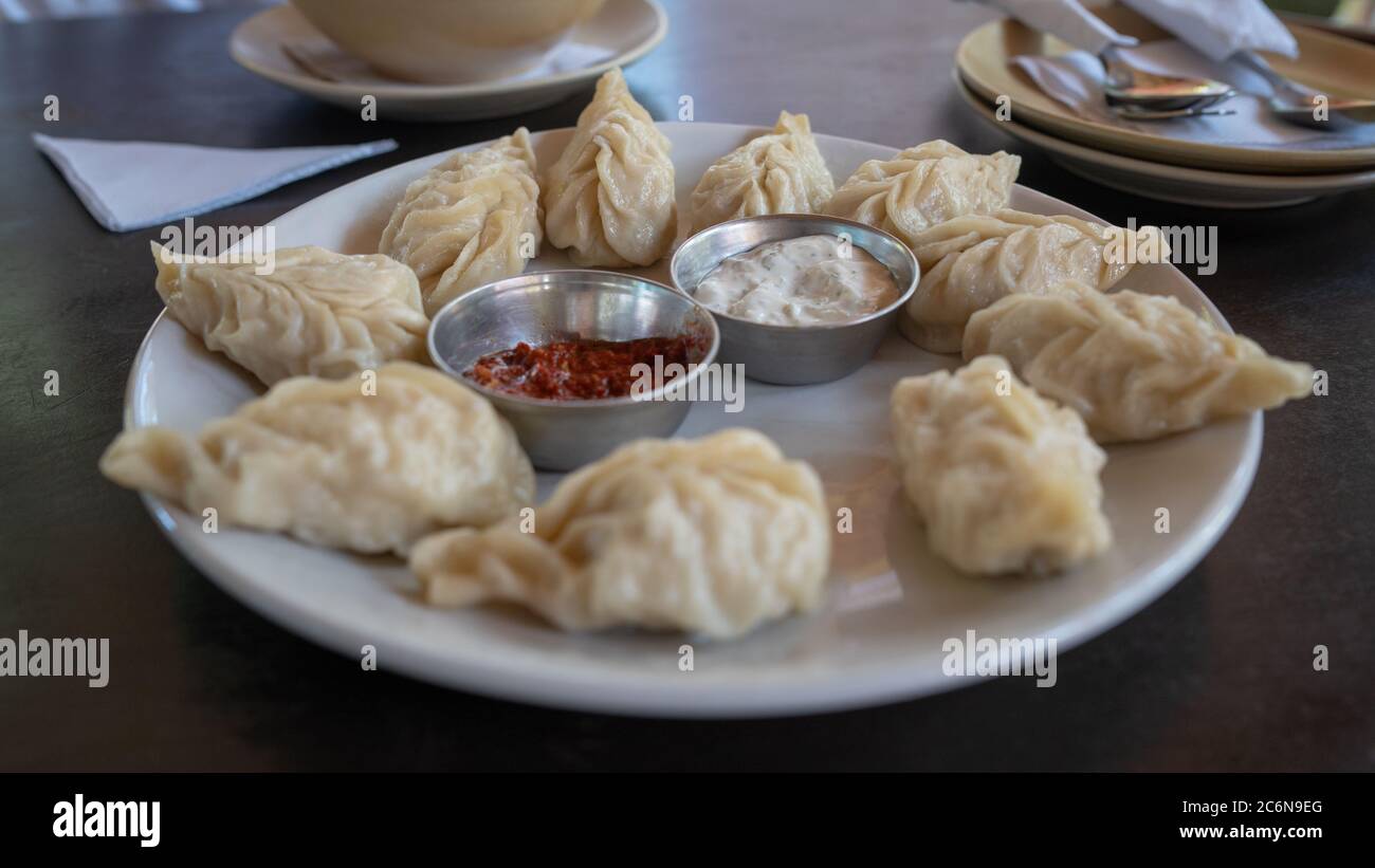 A dish of the tibetan fried momo with a sauce. Momo is a dish of dough ...