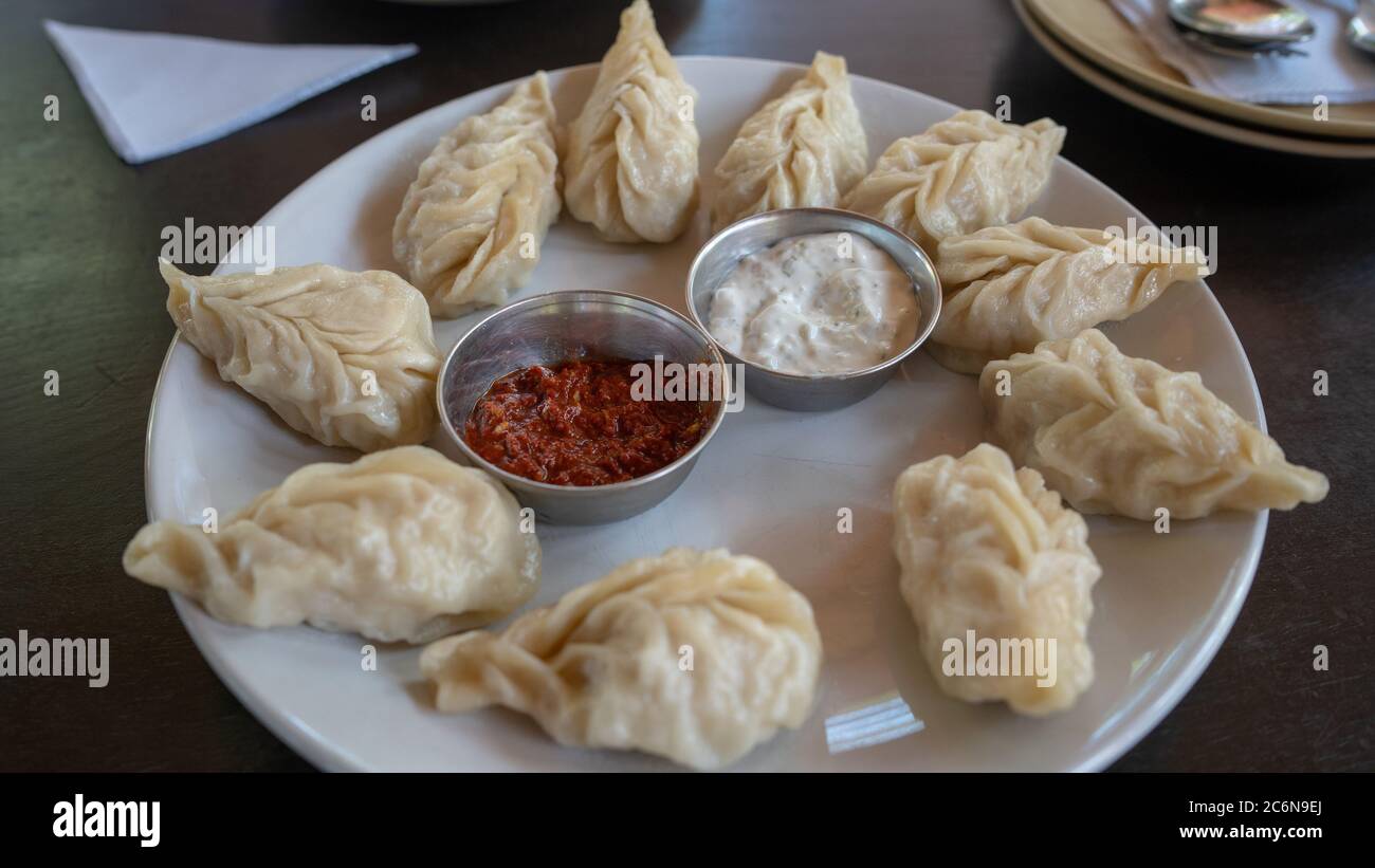 A dish of the tibetan boiled momo with a sauce. Momo is a dish of dough ...